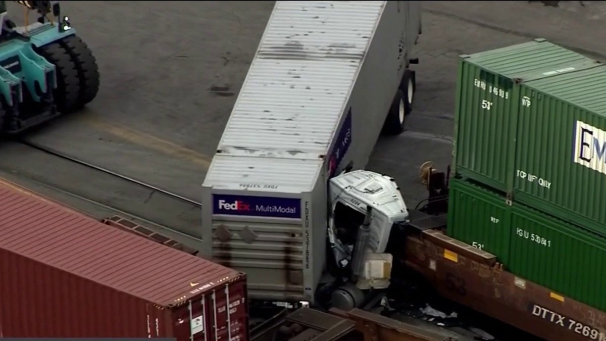 1 dead after freight train strikes semi truck on railyard tracks in ...
